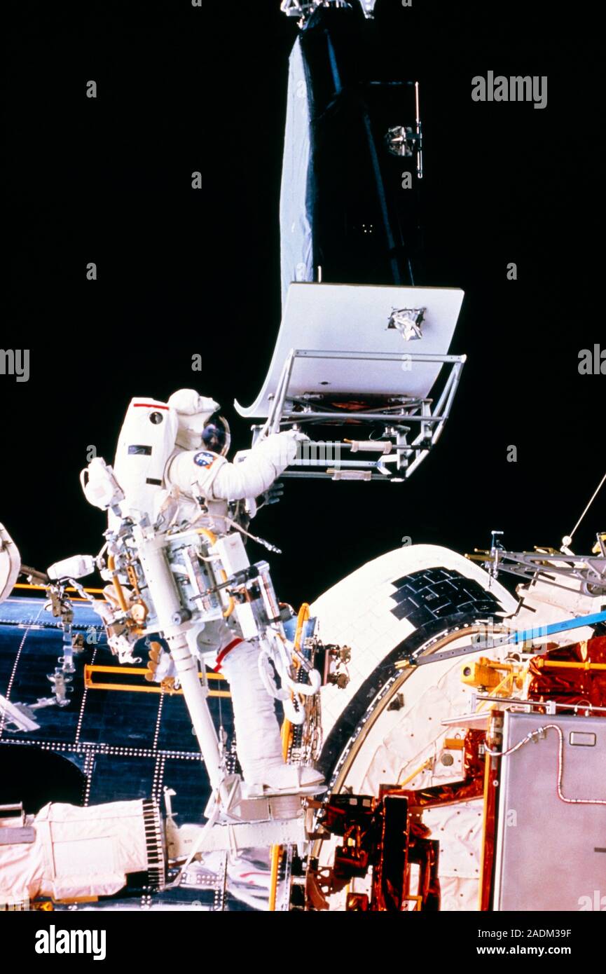 Servicing the Hubble Space Telescope. Astronaut Jeffrey Hoffman holding ...