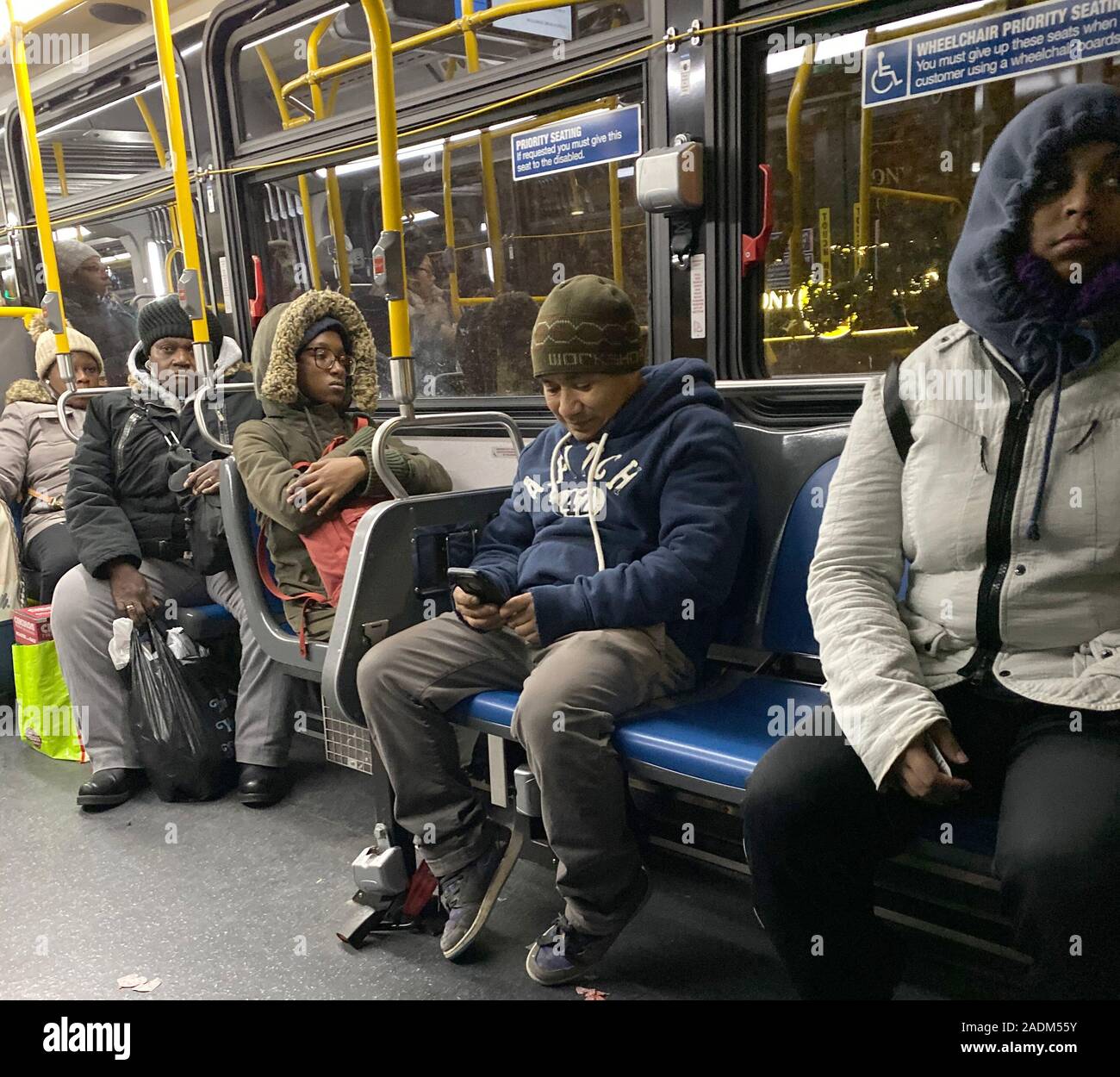 People riding a city bus after work in the evening in Brooklyn, New ...