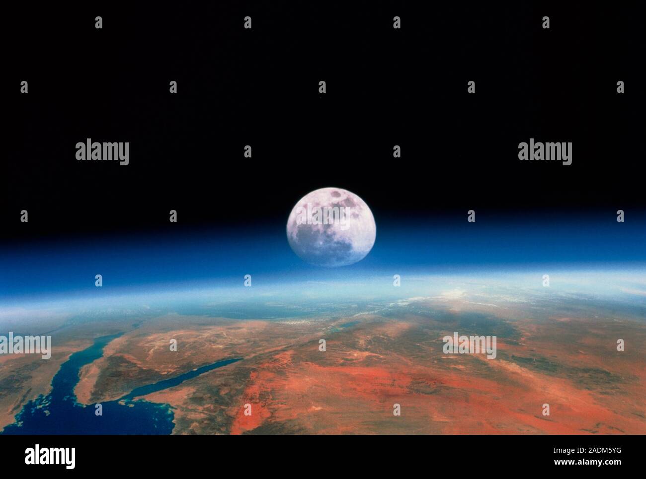 Moon over Earth, composite image. The blue haze of the atmosphere is ...