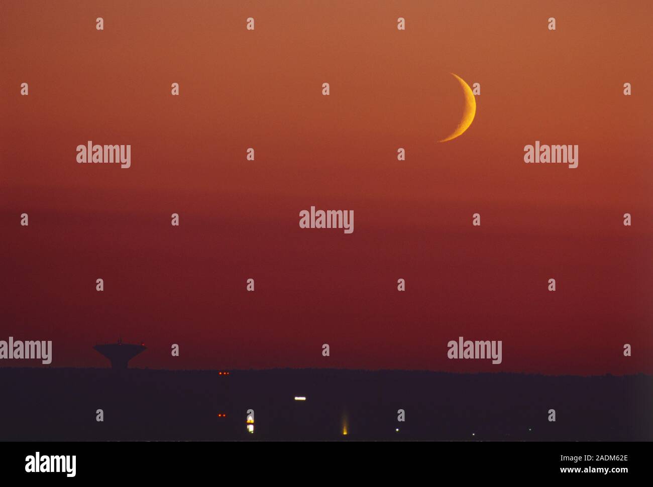 Crescent moon over a satellite dish. The Moon does not produce light ...