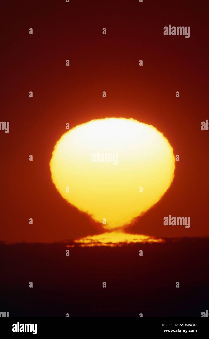 Distorted Sun at sunset. A distorted solar disc at sunset, with a ...