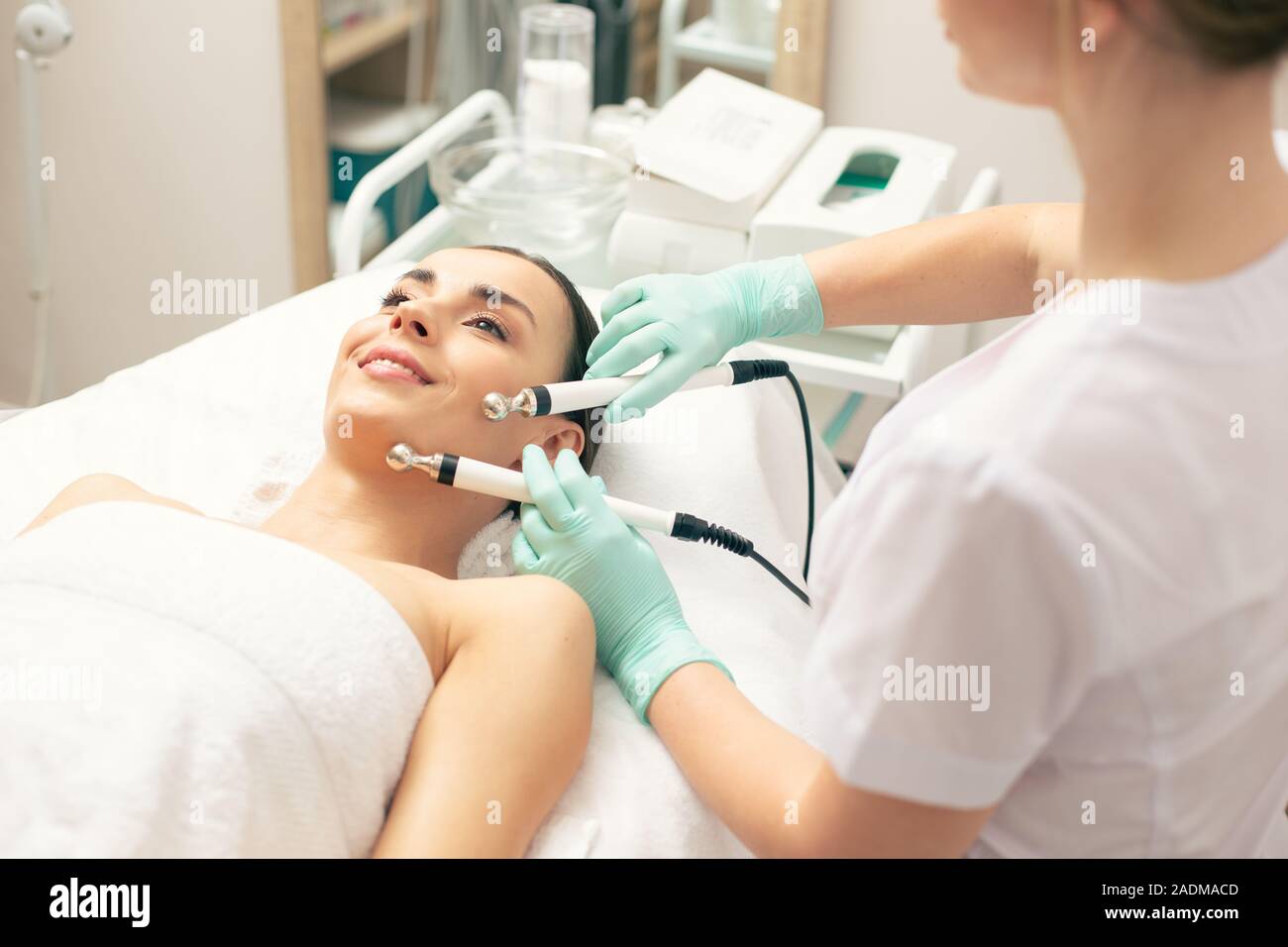Process of the microcurrent therapy and smiling woman undergoing it ...