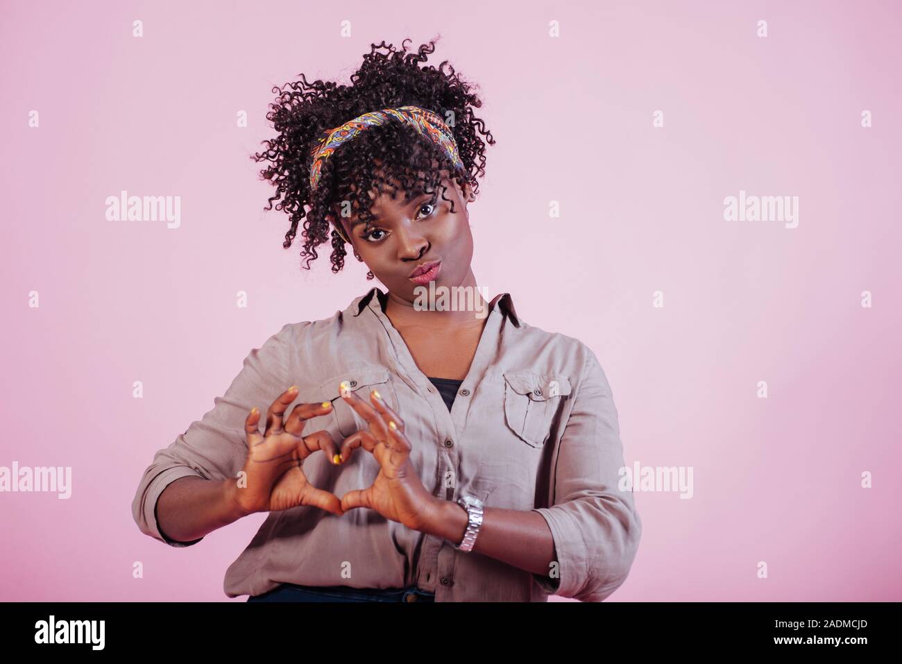Heart shaped gesture. Attractive afro american woman in casual clothes ...