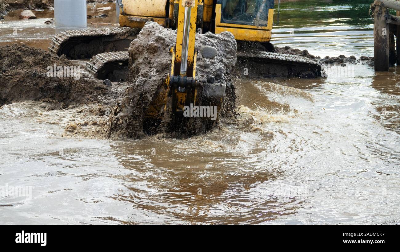 Excavator working in the small forest river, excavator bucket ...