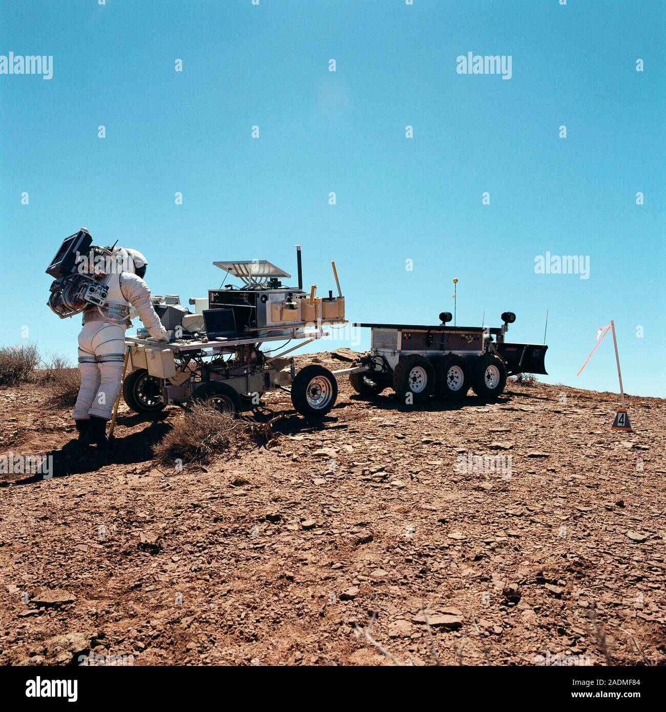 NASA field study. Astronaut with a science trailer (centre left ...