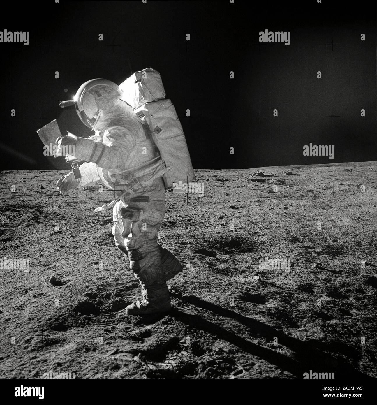 Apollo 14 astronaut Edgar D. Mitchell walking on the Moon and studying ...