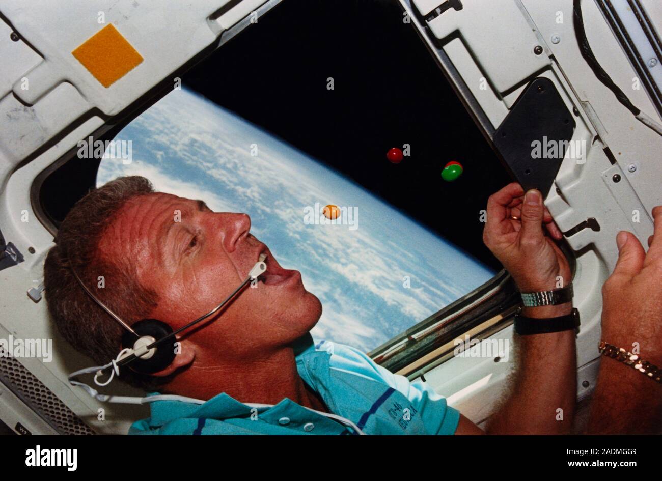 Space snack. Astronaut Loren Shriver attempting to catch floating ...