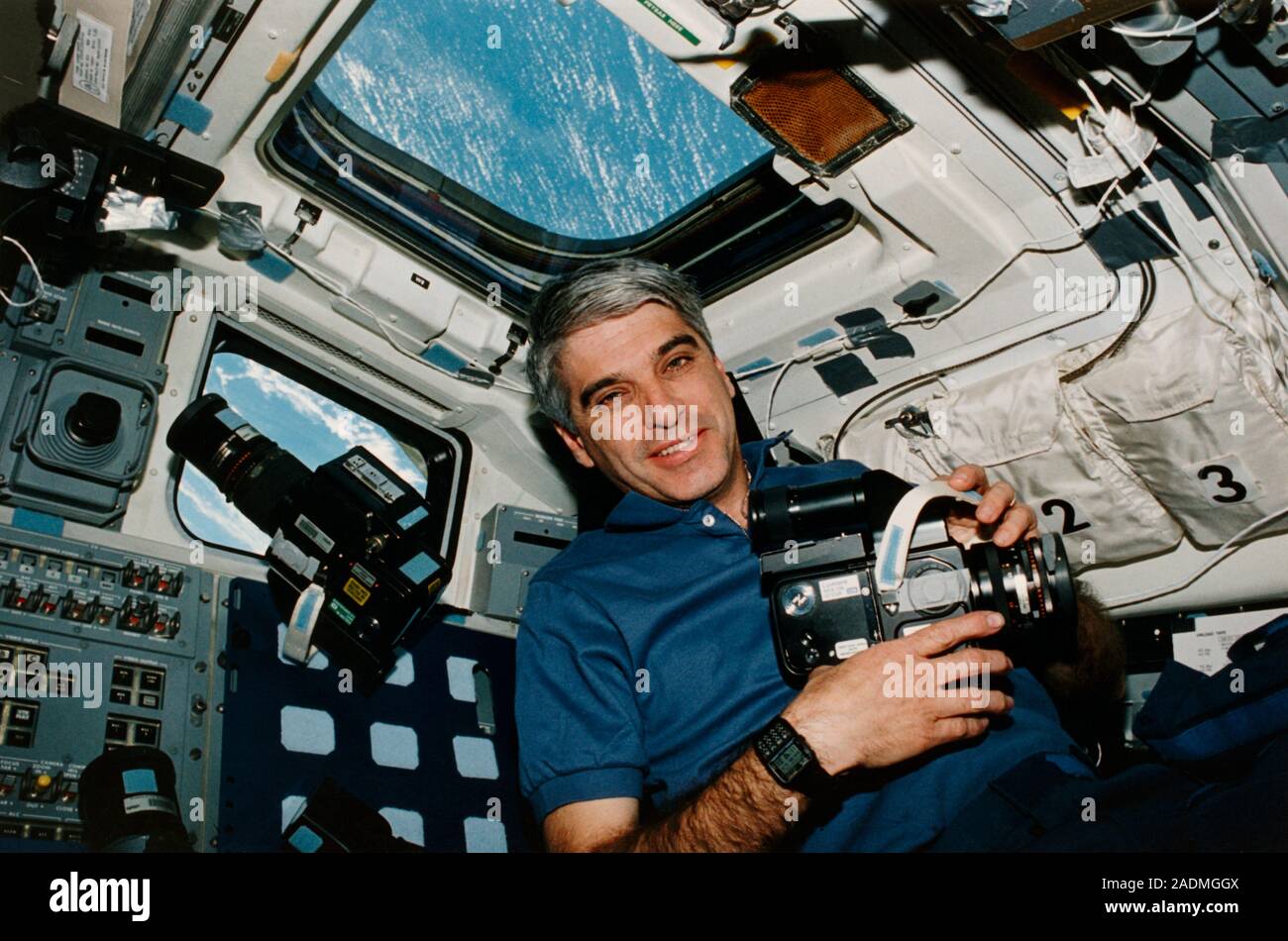 Preparing to photograph the Earth. Astronaut Sidney Gutierrez prepares ...