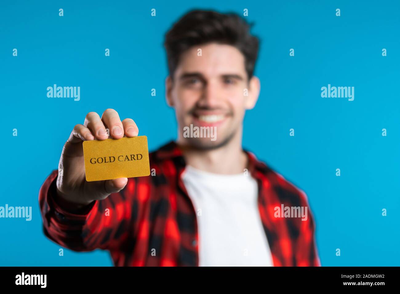 Successful man in plaid shirt showing unlimited gold credit card on ...
