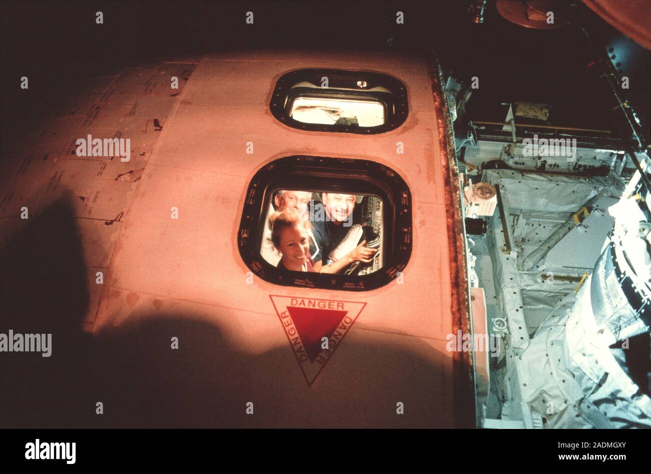 ISS construction. Three astronauts looking out of a window of the Space ...