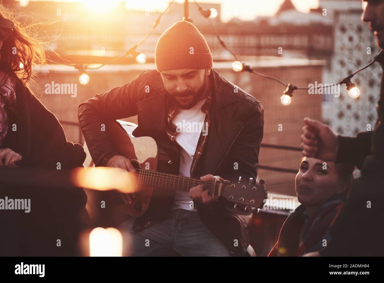 Good weather. Friends have fun at rooftop party with decorative colored ...