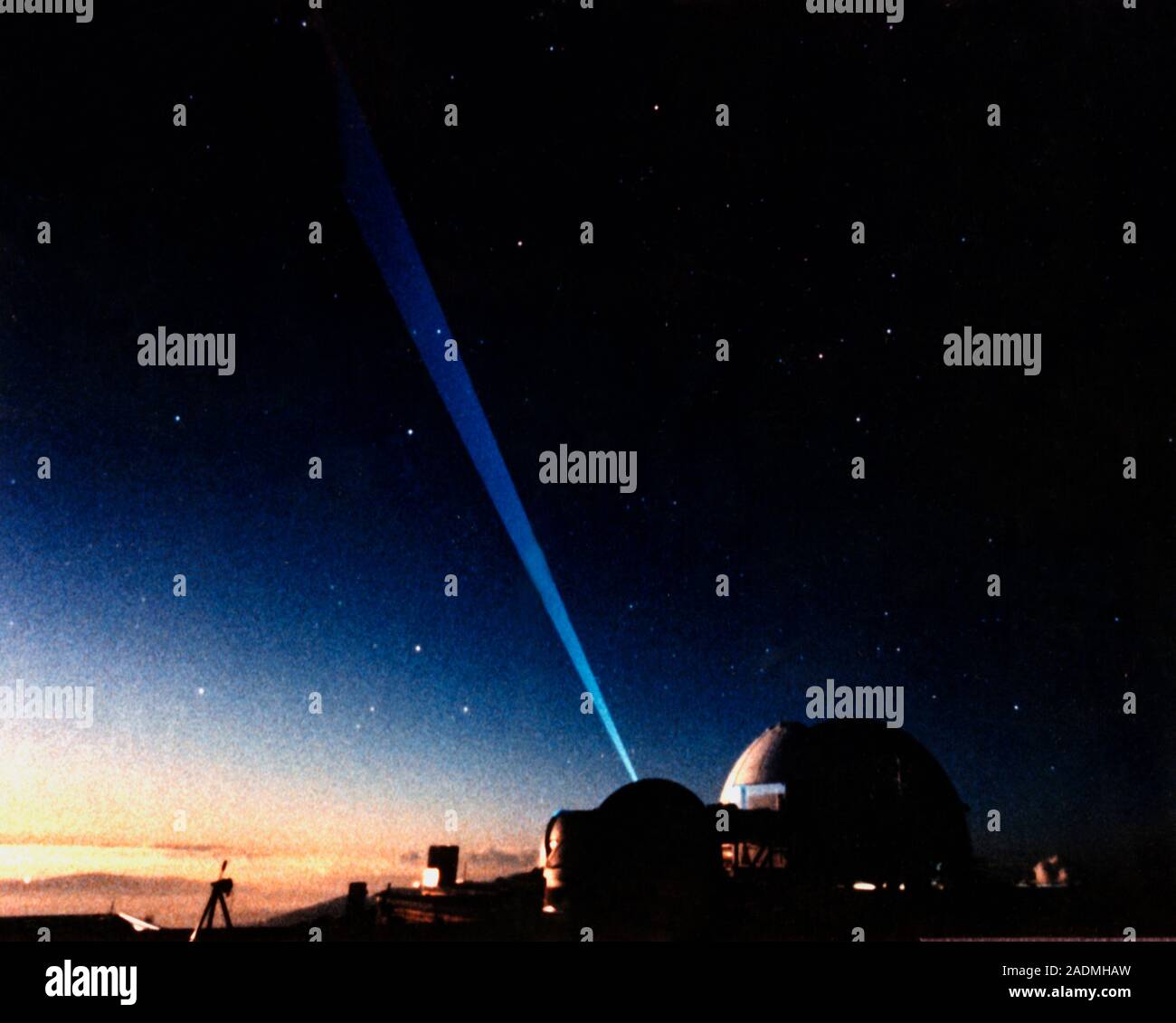 A ground-based, low-power laser beam is fired into the night-sky to ...
