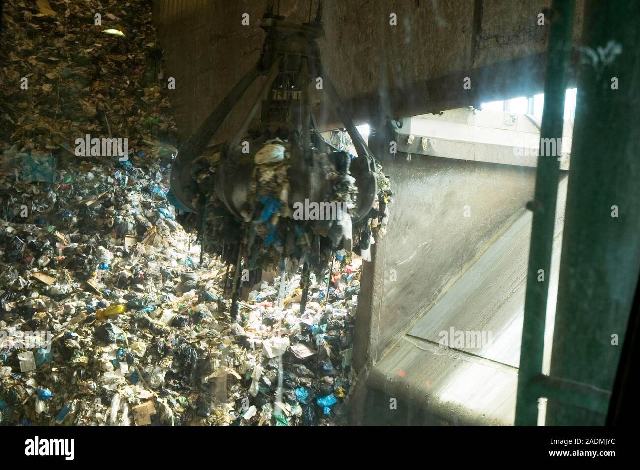 Domestic waste handling at an incinerator. Use of a grab-claw to move ...
