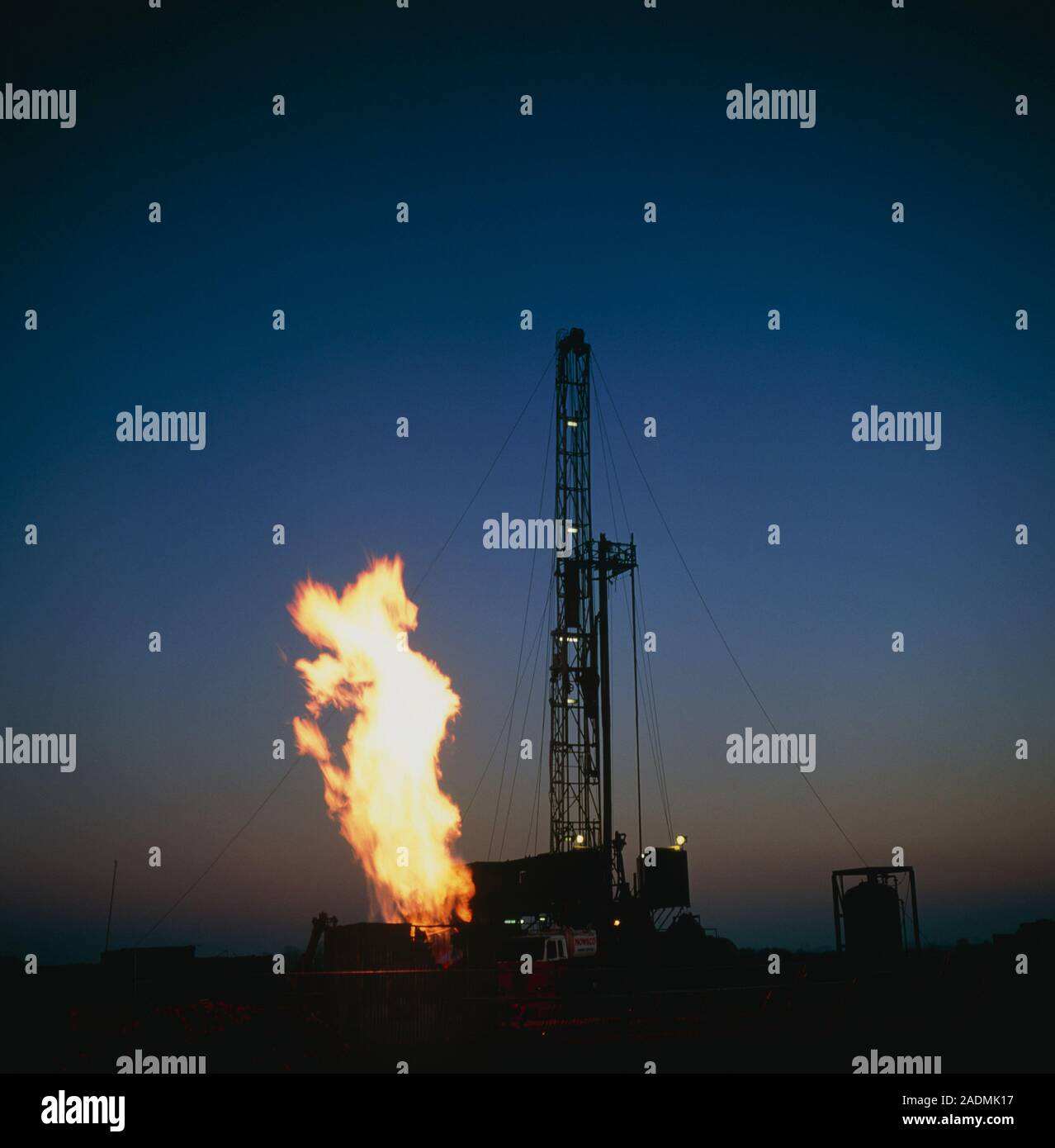 Gas well. View of a gas flame by the drilling tower at an onshore gas ...