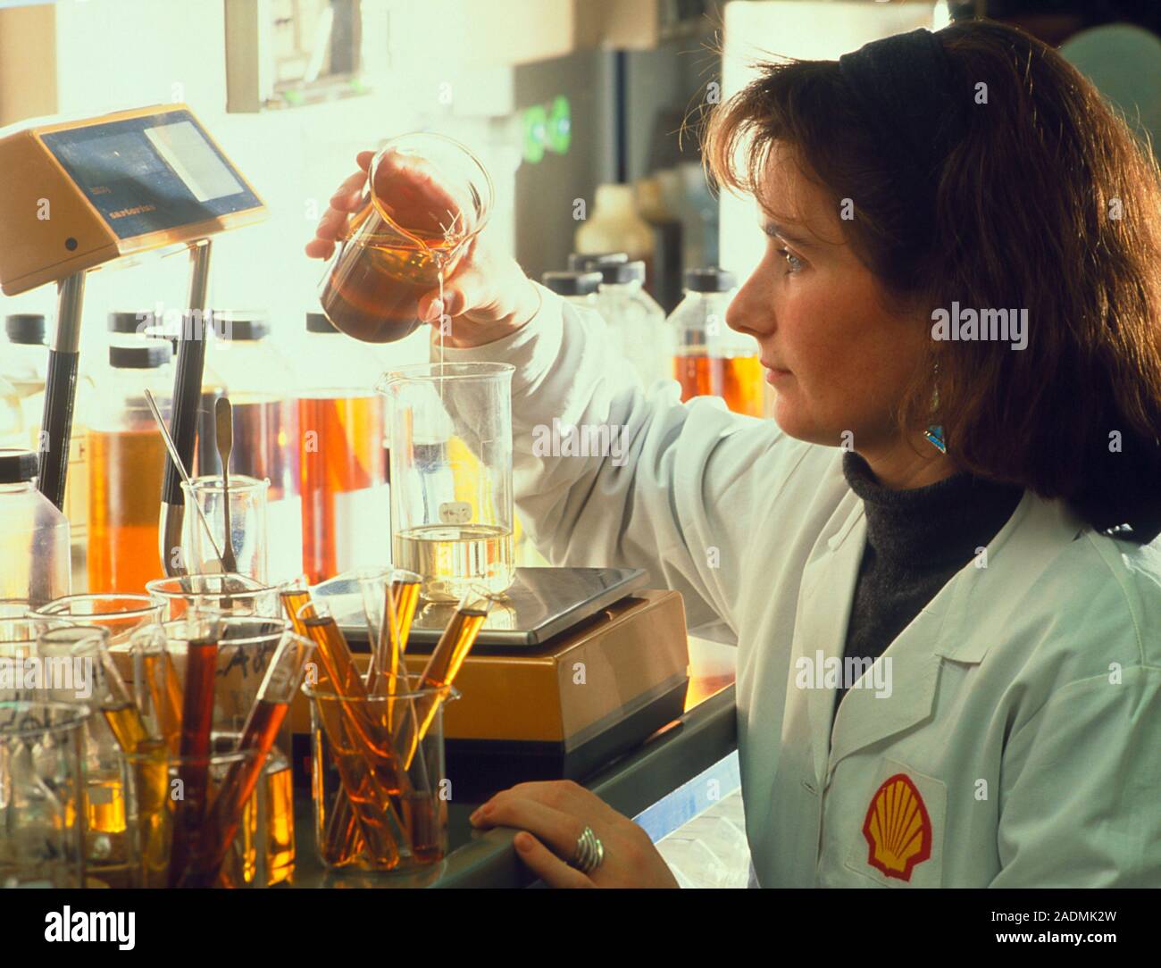 Oil analysis. A female technician prepares mineral oil samples for ...