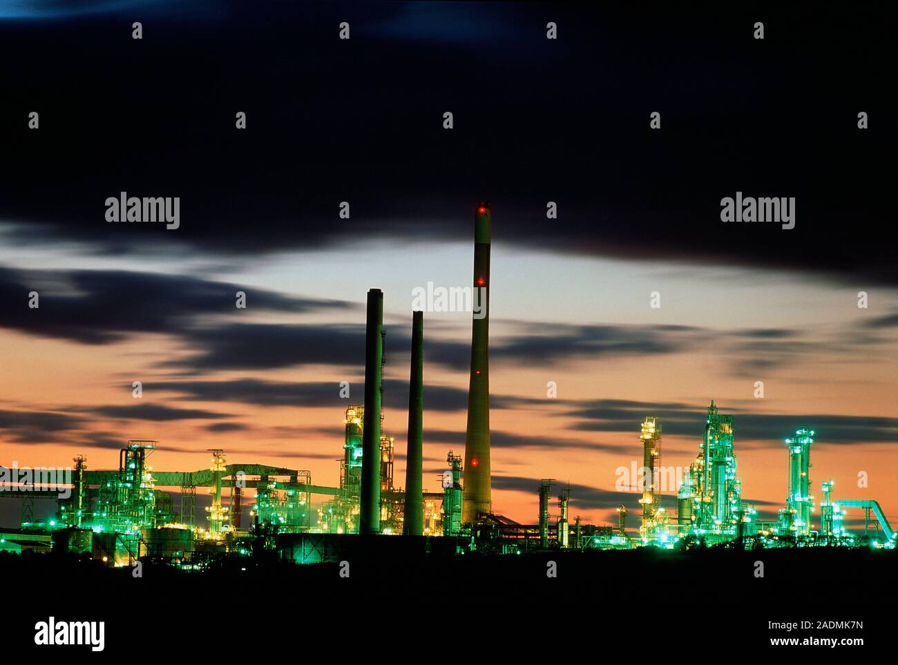Oil refinery. Oil refinery with towers and chimneys at dusk. In an oil ...