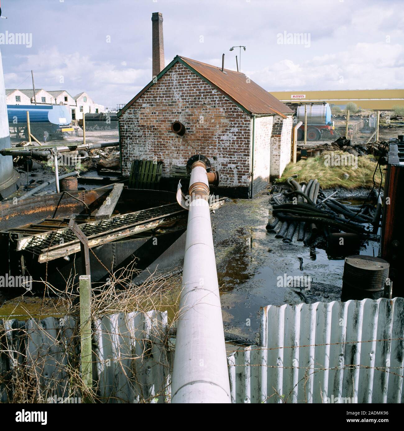Abandoned oil storage depot. Oil pollution can be seen in the water and ...