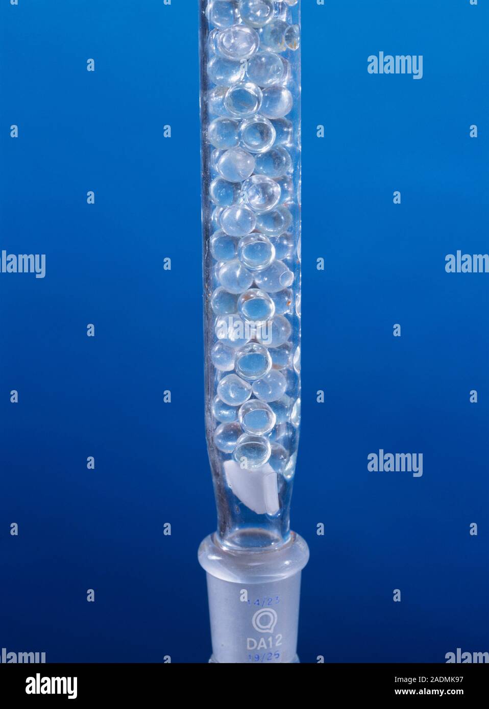 Fractional distillation of oil. Glass beads in a glass column being ...