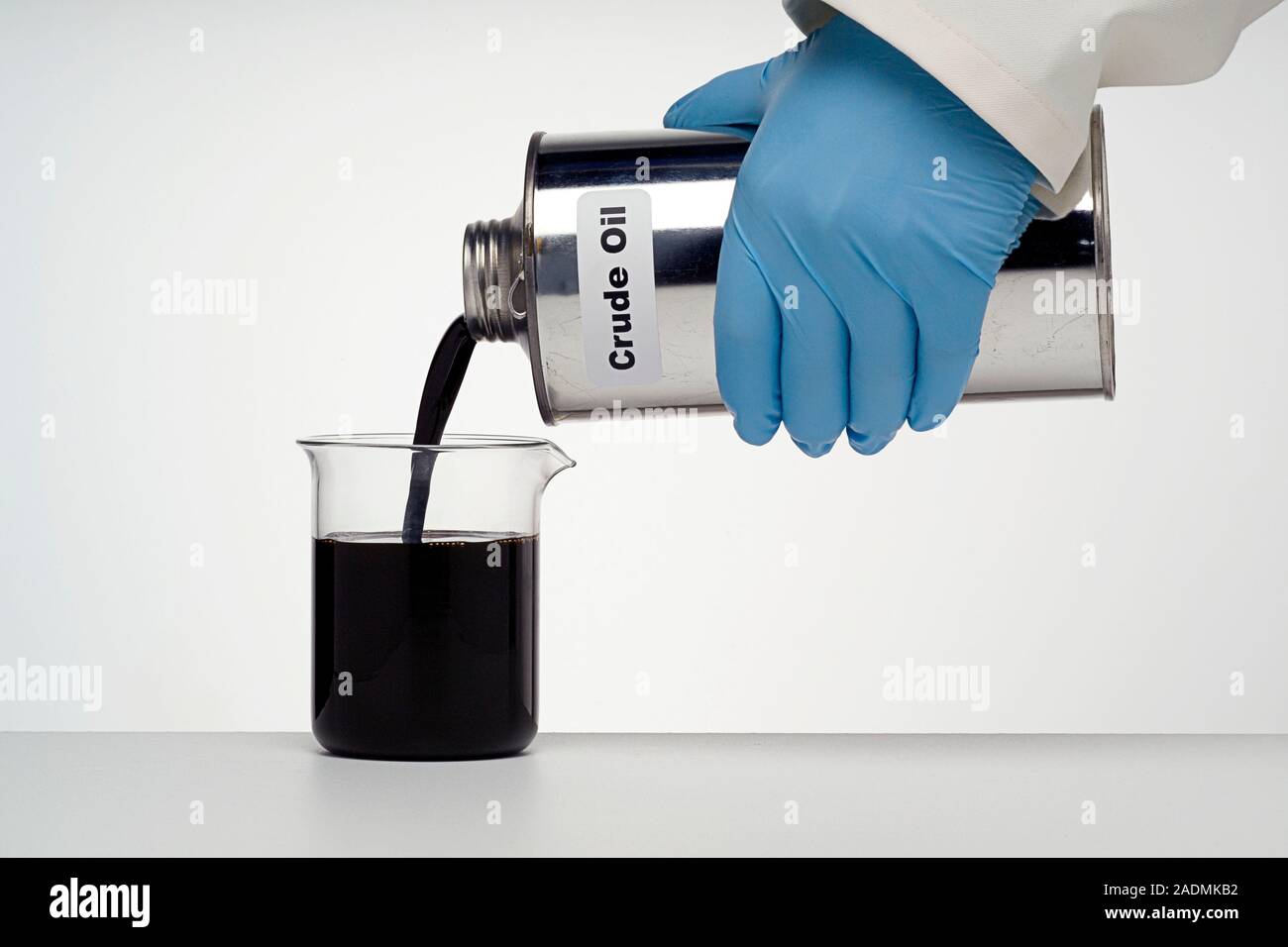 Crude oil being poured into a beaker. Crude oil is oil from the ground ...