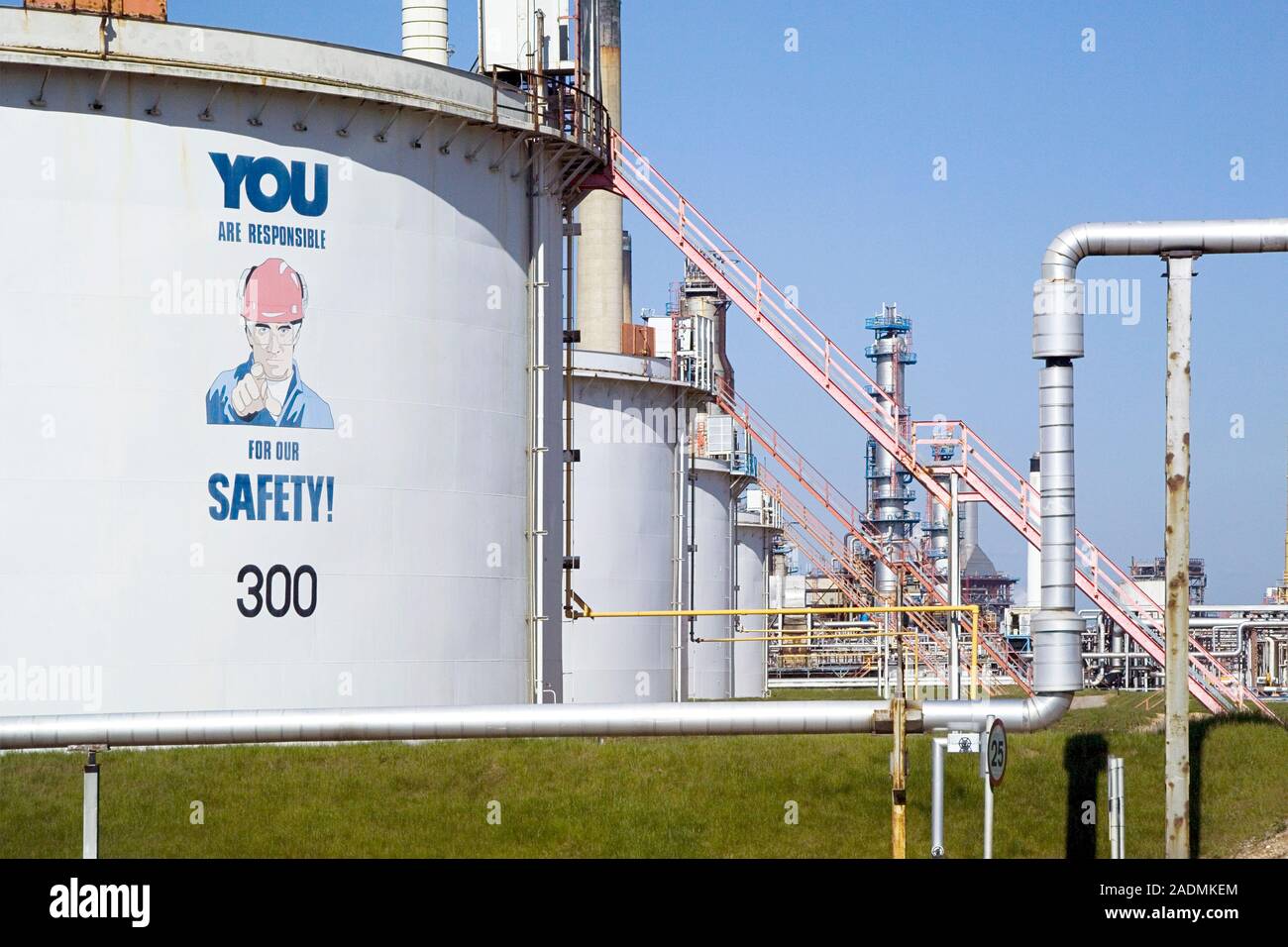 Oil refinery storage tanks and a safety sign. These tanks contained ...