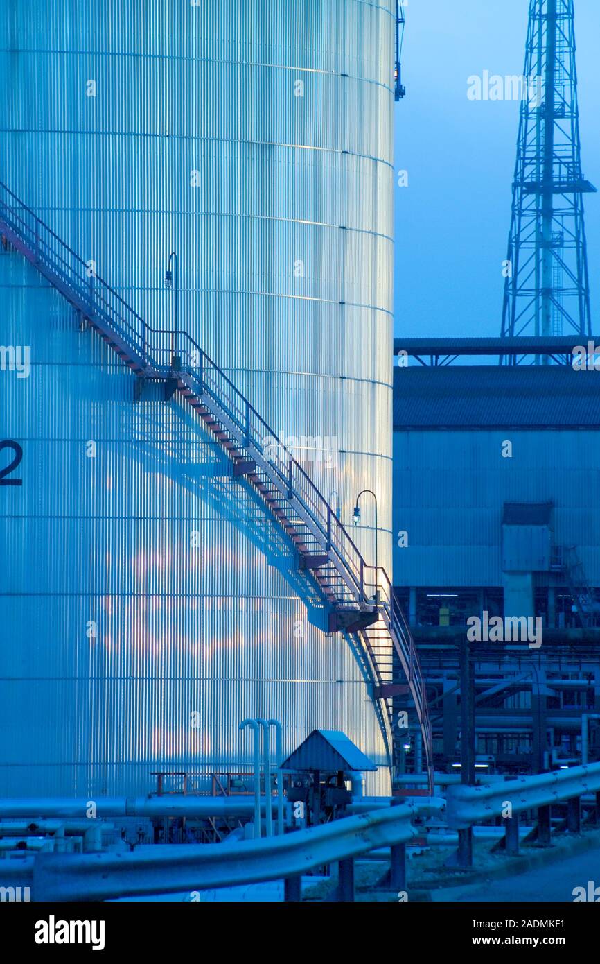 Oil refinery storage tank at dusk. This tank contains intermediate ...
