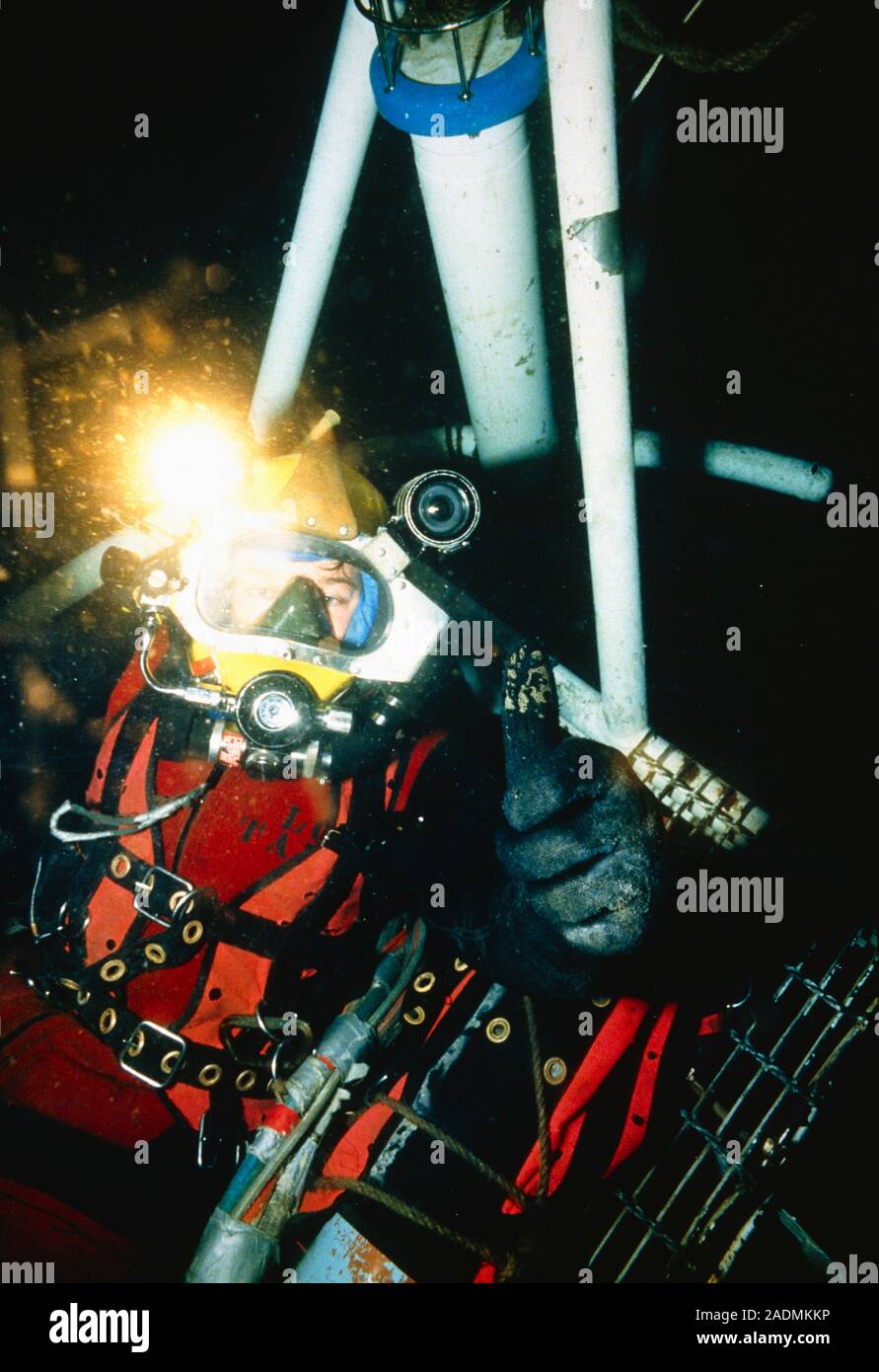 Saturation diver wearing helmet-mounted television camera, photographed ...