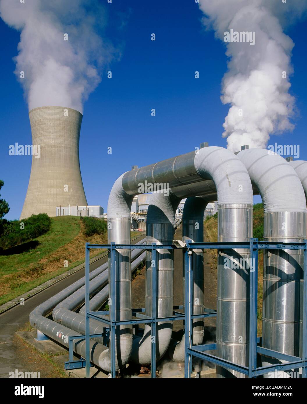 Geothermal power. Steam-carrying pipes and a cooling tower at the ...