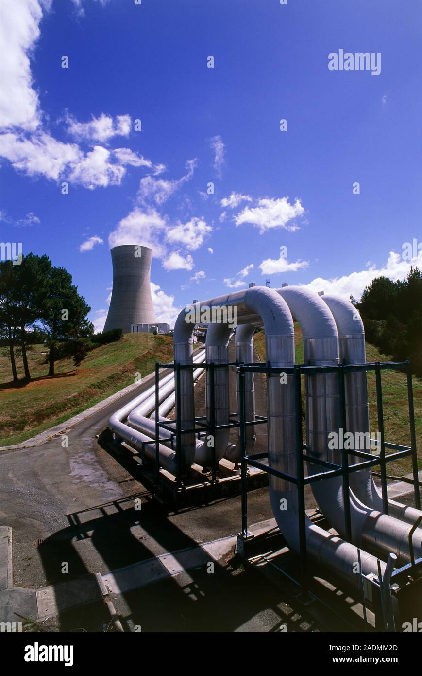 Geothermal power. Steam-carrying pipes and a cooling tower (at centre ...