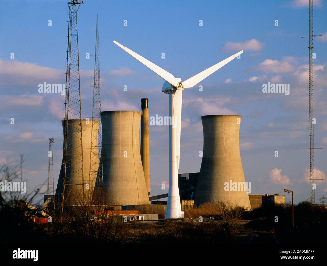 Wind turbine and traditional oil-fired power station. Photographed at ...