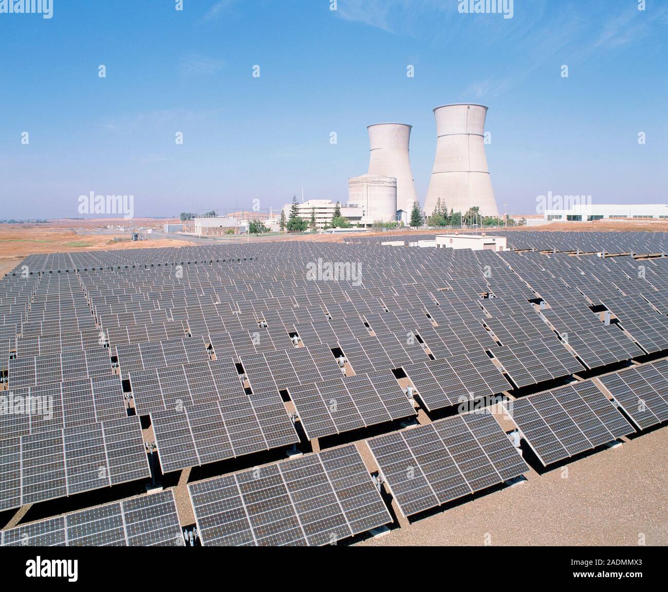Solar power station. Array of solar panels (lower frame) at a solar ...