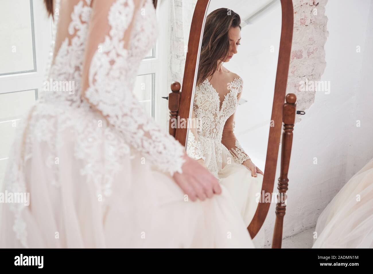 Reflection of bride in the mirror. The process of fitting the dress in ...