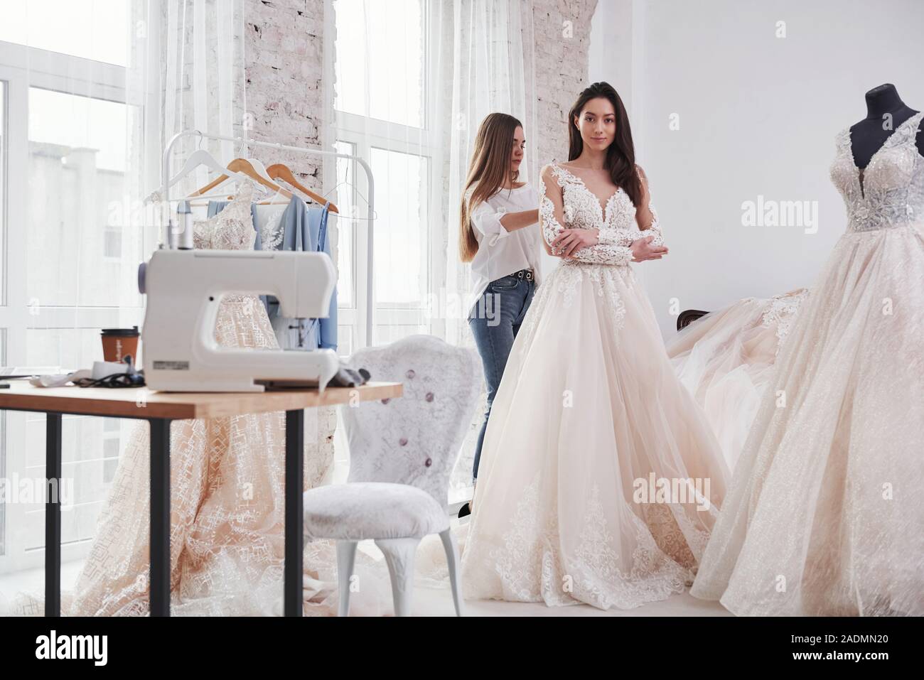 Helping the bride. The process of fitting the dress in the studio of ...