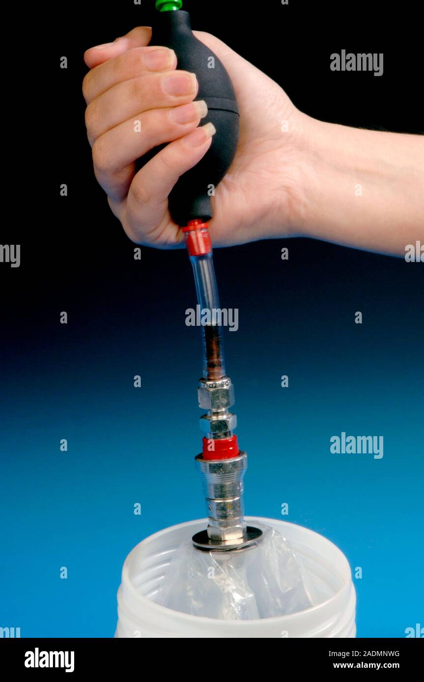 Radon gas sampling equipment. Hand-operated suction pump being used to ...