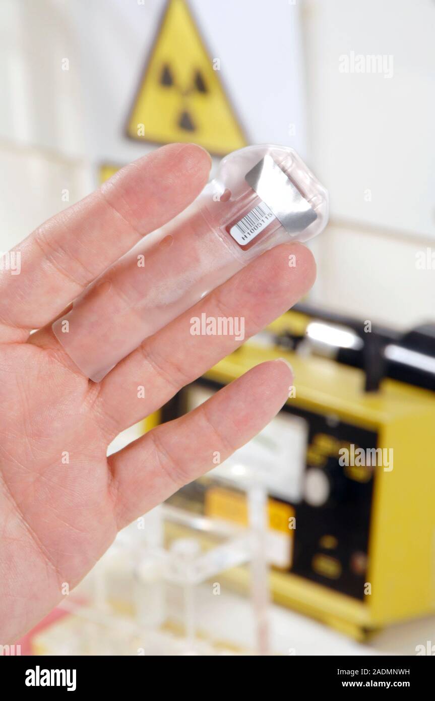 Using a personal radiation dose meter. Hand of a laboratory worker with ...