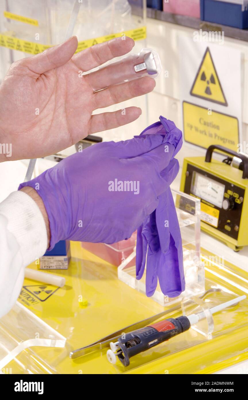 Using a personal radiation dose meter. Hands of a laboratory worker ...