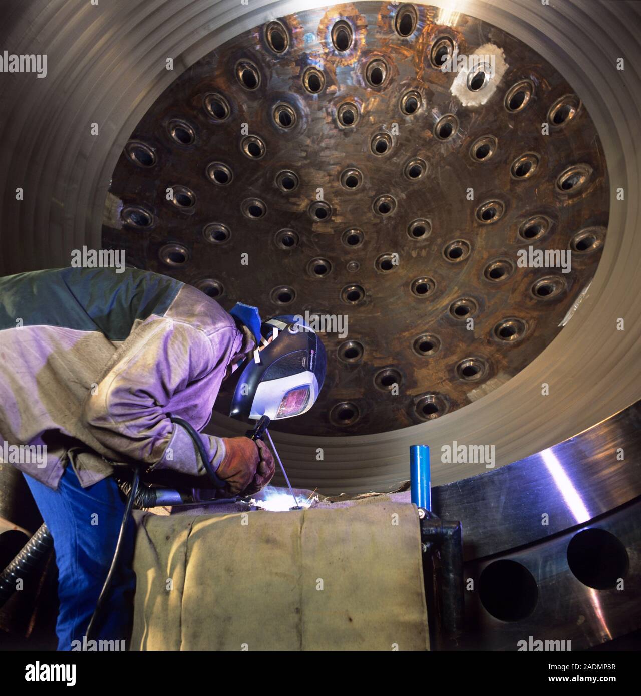 Nuclear power station construction. Worker using a welding tool ...