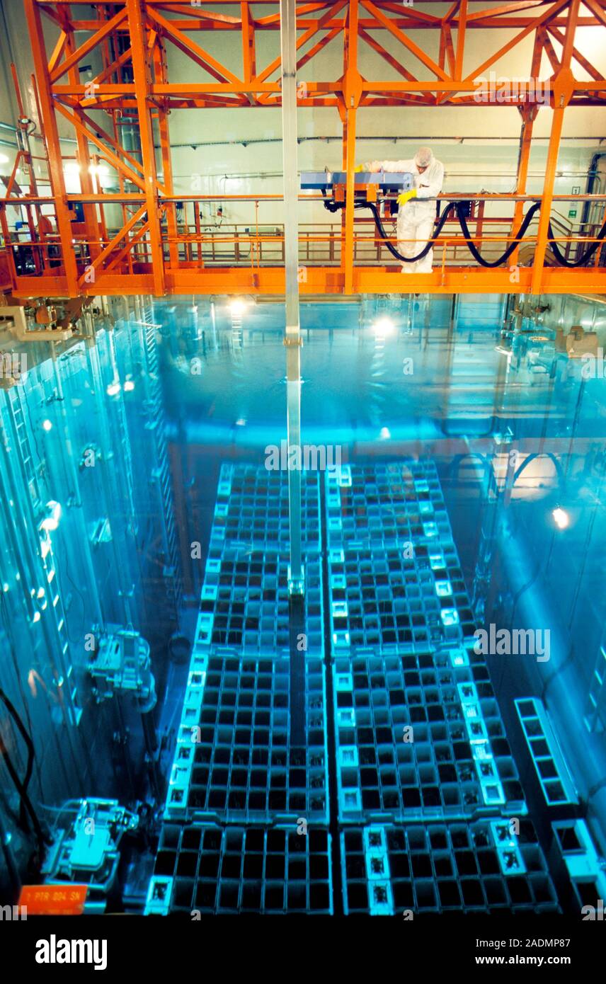 Nuclear reactor. Worker preparing fuel rod for loading into a nuclear ...
