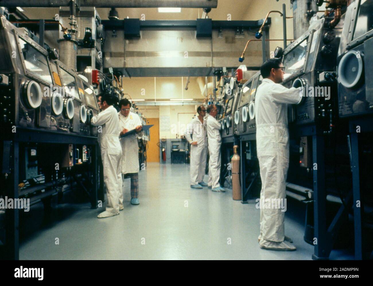 Workers using a glovebox to handle radioactive plutonium compounds at a ...