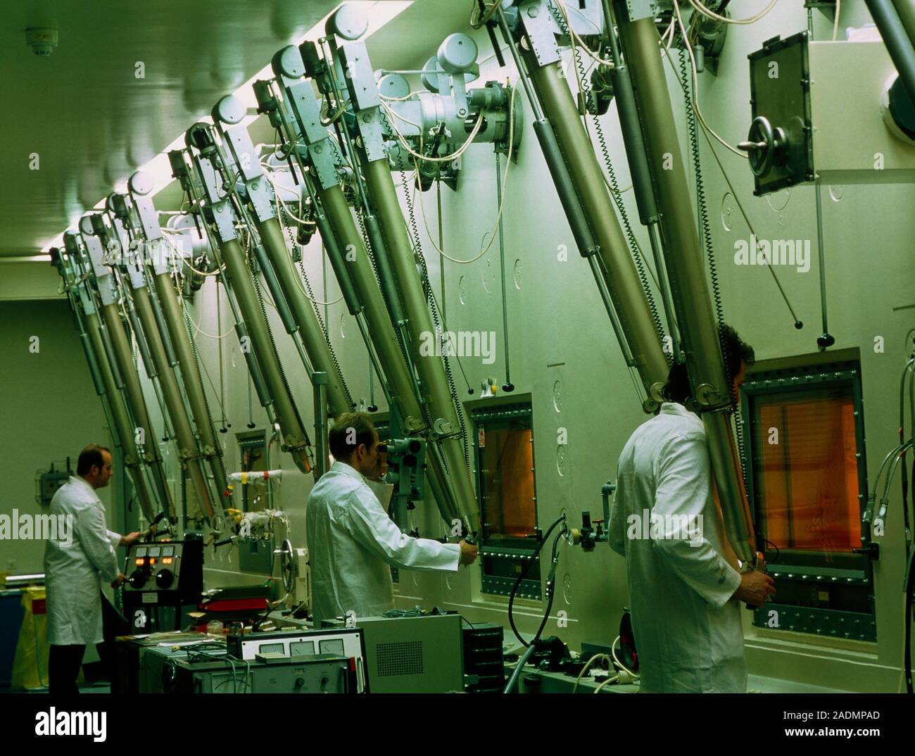 Radioactive handling. Technicians use levers to control robot arms (not ...