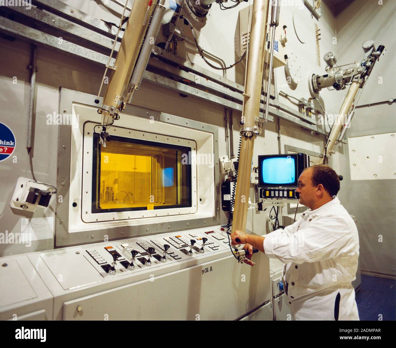 Radioactive handling. Technician using levers to control a robot arm ...