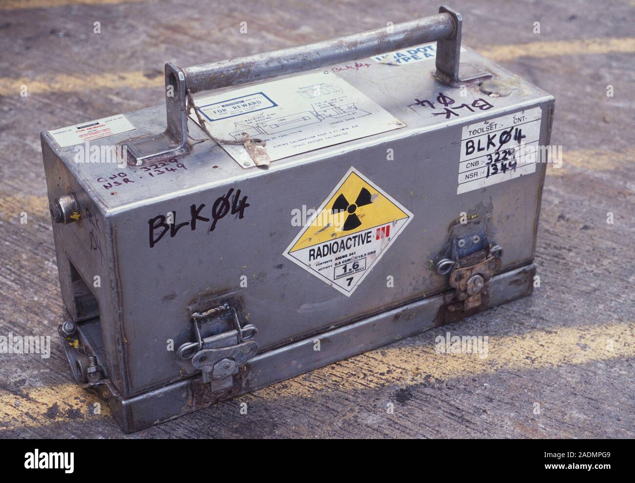 Radioactive container with a warning sticker on its side. It is housing ...