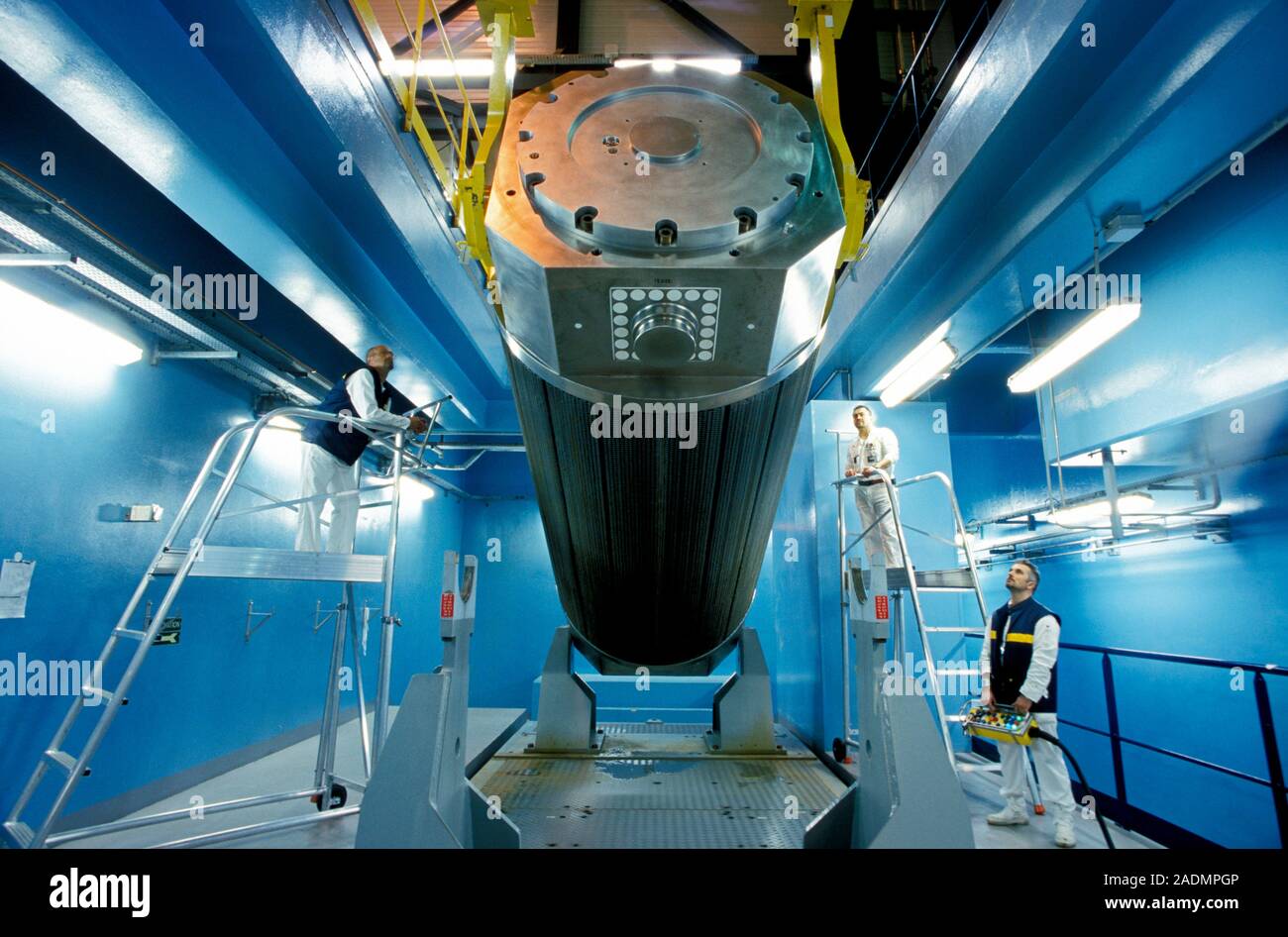 Nuclear fuel reprocessing. Workers preparing to store a container of ...