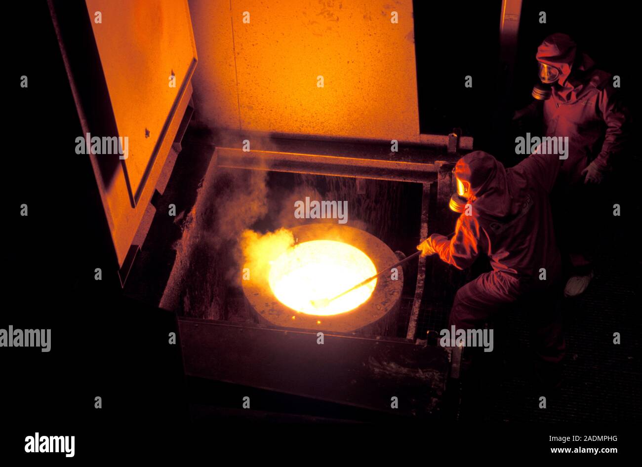 Low-level nuclear waste. Workers casting ingots of molten metal as part ...