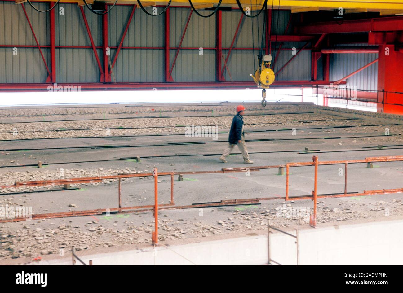Short-term nuclear waste. Worker and a crane at a nuclear waste storage ...