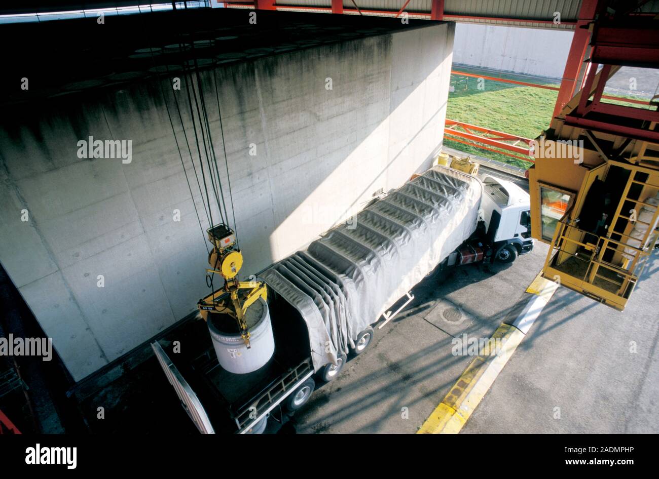Nuclear waste. Container (left) of nuclear waste being unloaded from a ...