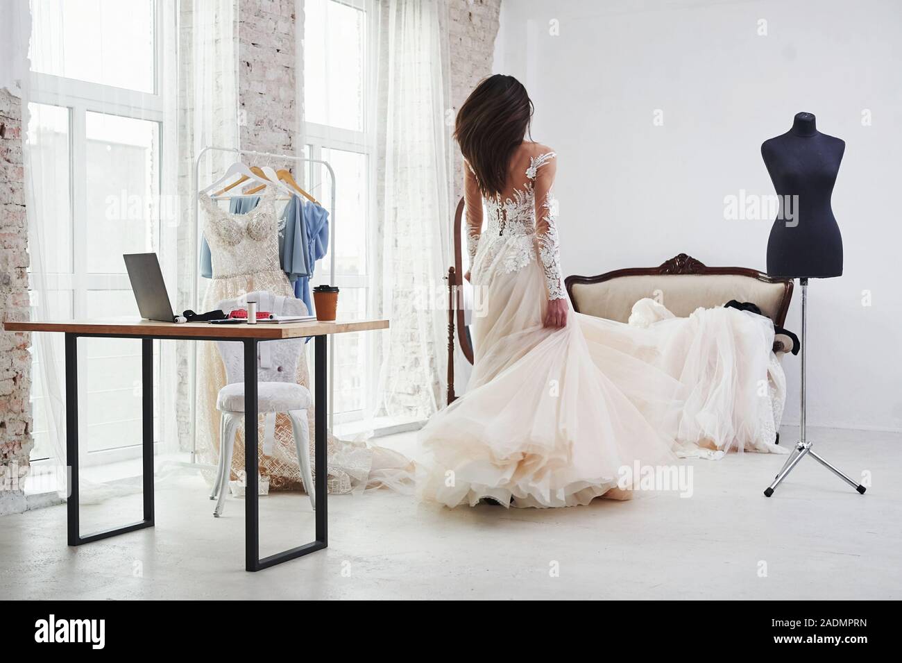 Picture in motion. The process of fitting the dress in the studio of ...