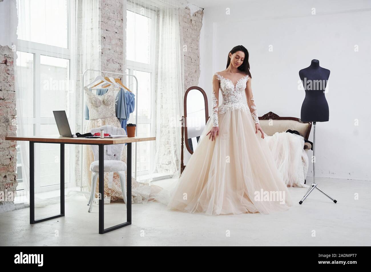 Portrait on the white clean room. The process of fitting the dress in ...