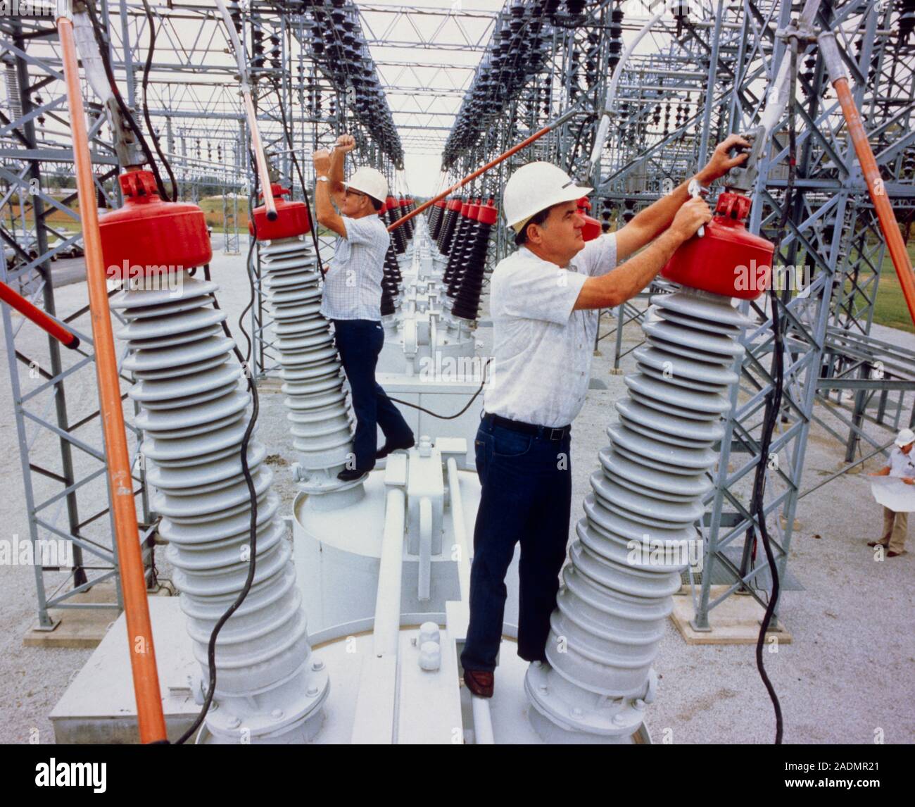 Workers maintaining insulators in the switchyard of a hydroelectric ...