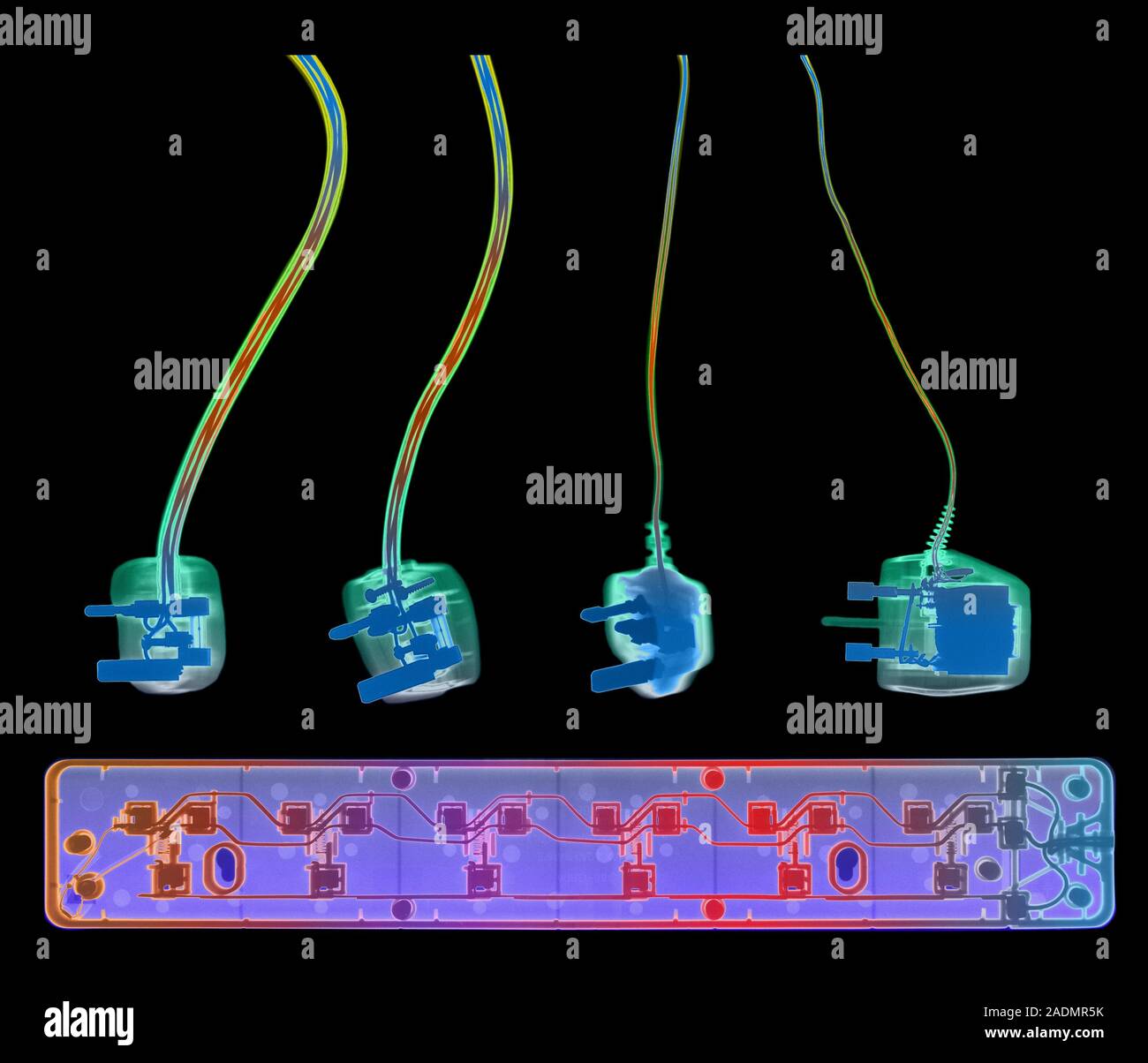 Electrical plugs and socket extension. Coloured X- ray of four 3-pin ...