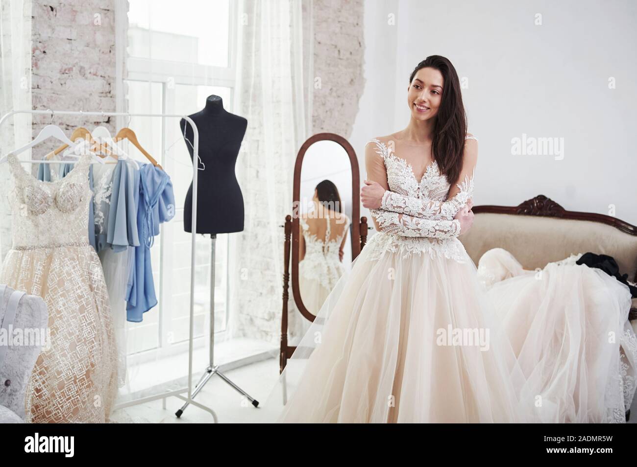 With arms crossed. The process of fitting the dress in the studio of ...